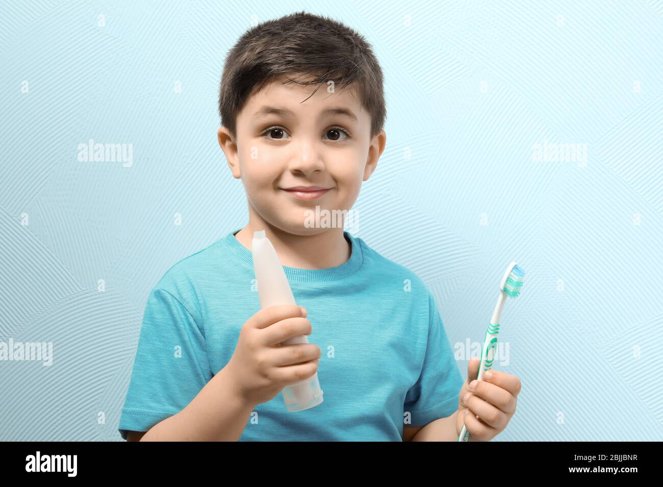 Cute boy with toothbrush and paste on color background. Teeth cleaning ...