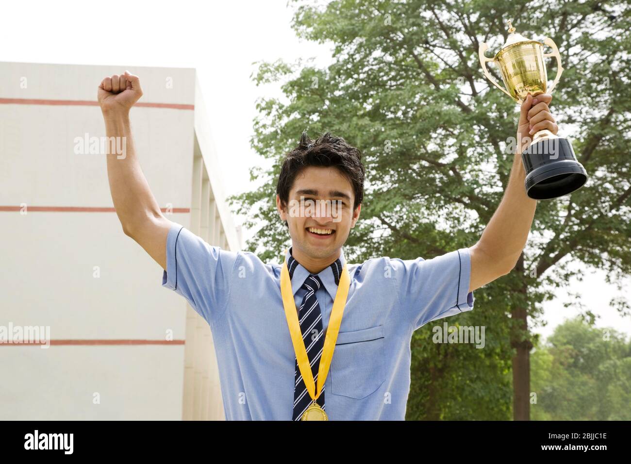 Student holding a trophy triumphantly Stock Photo - Alamy