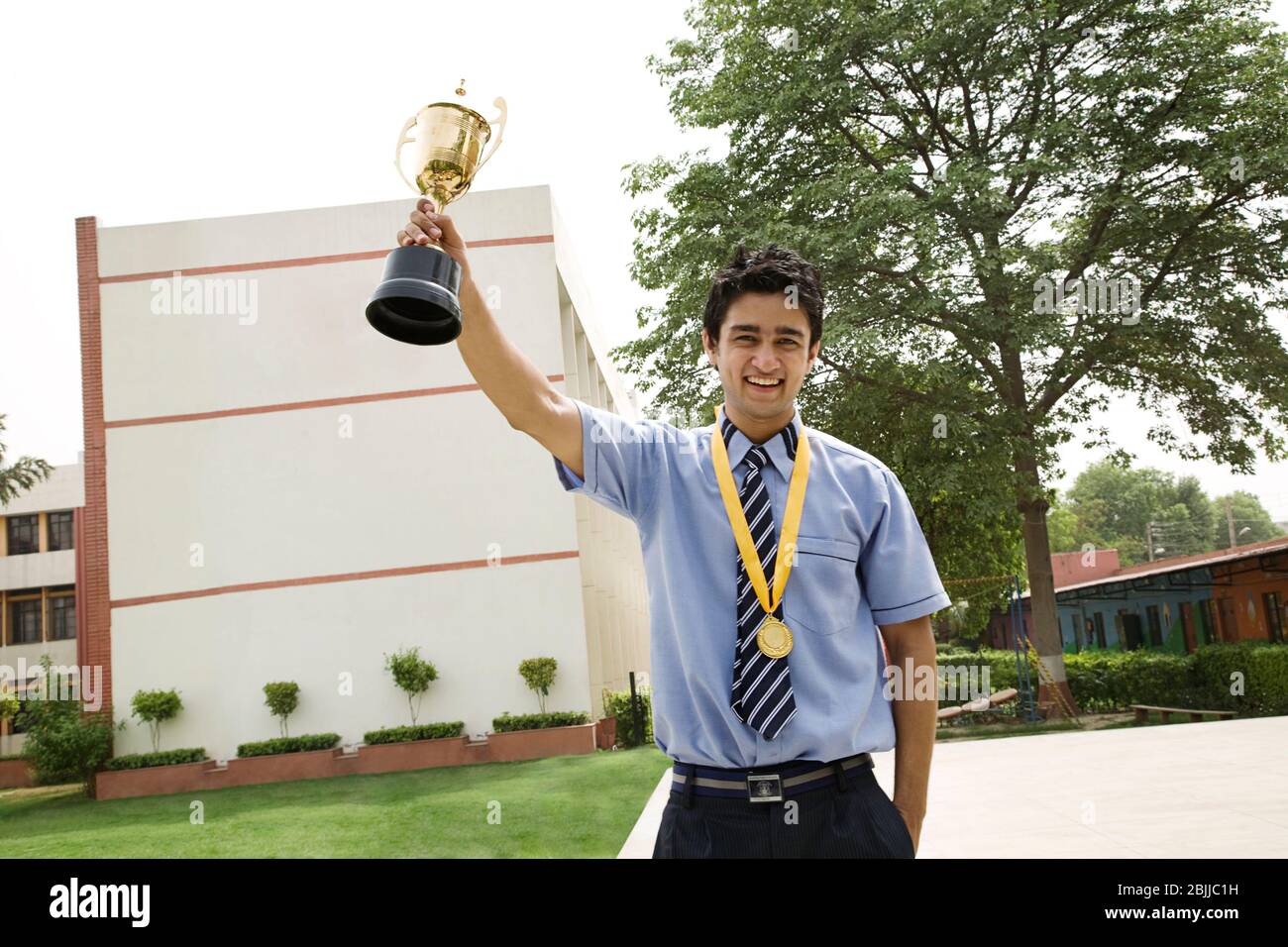 Student holding a trophy triumphantly Stock Photo - Alamy