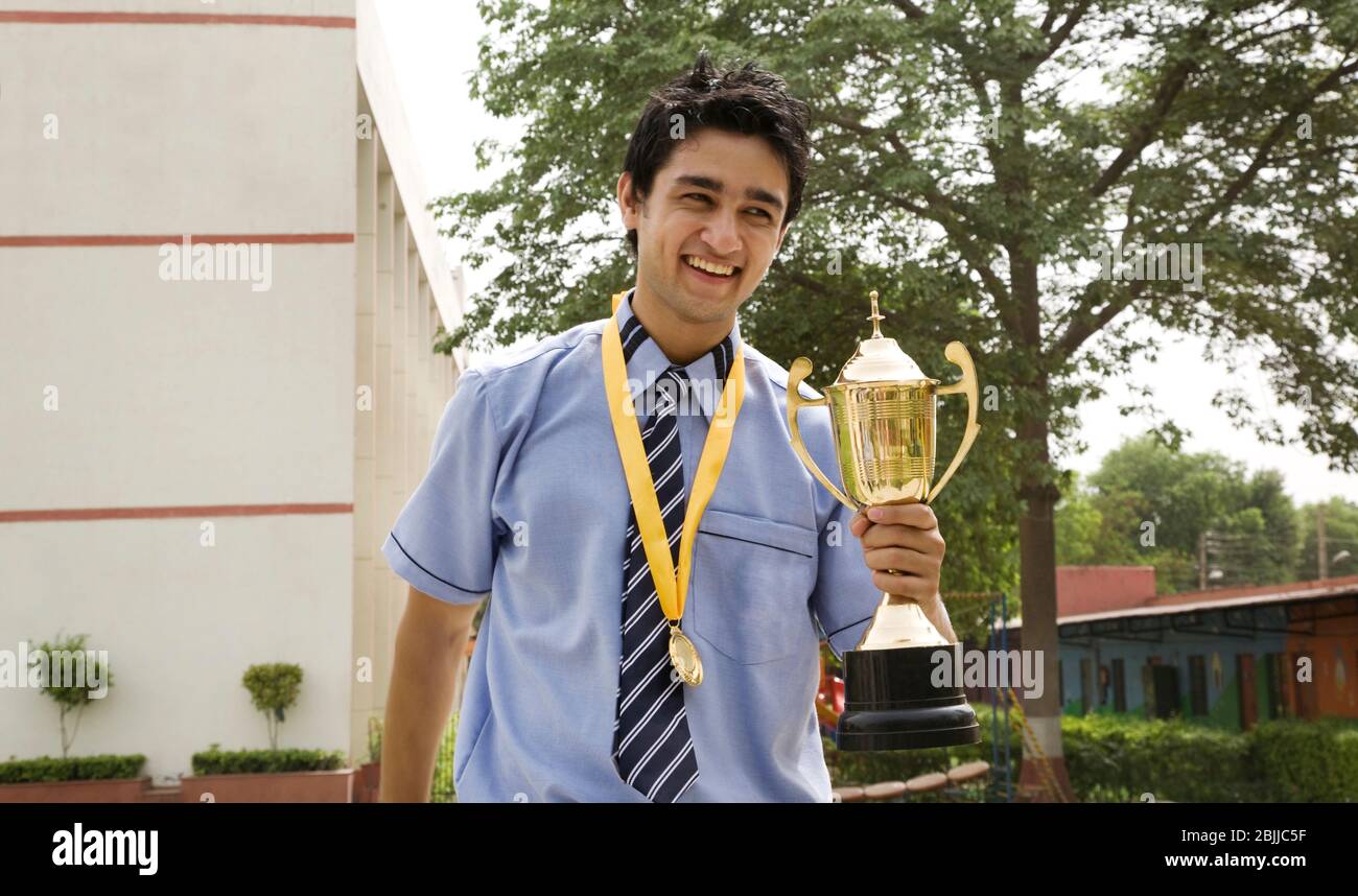 Student holding a trophy Stock Photo - Alamy
