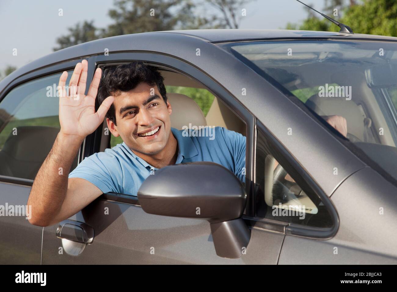 Man waving from his car Stock Photo - Alamy