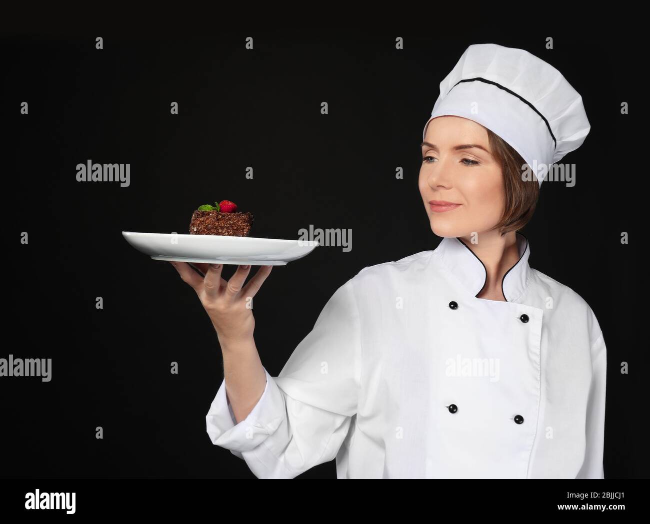 Female chef with dessert on dark background Stock Photo - Alamy