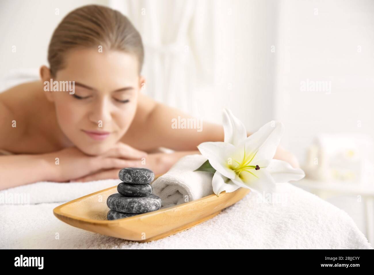 Spa set in salon with blurred woman on background Stock Photo - Alamy