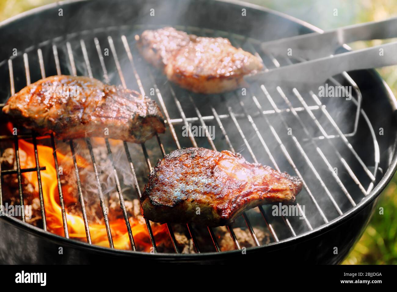 Tasty steaks on barbecue grill, close up Stock Photo - Alamy