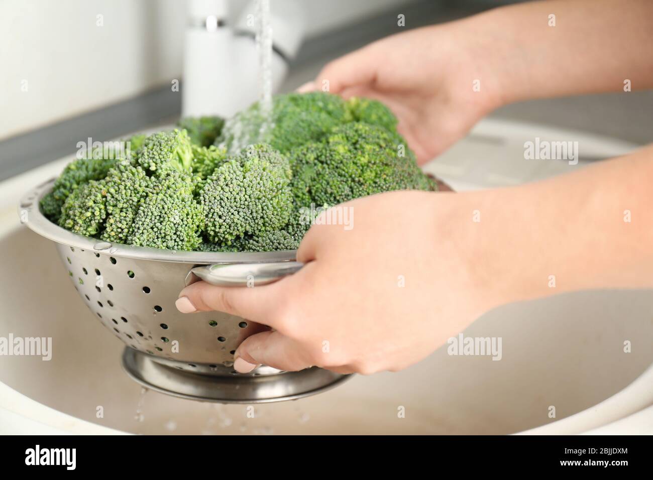 Washing broccoli in kitchen hi-res stock photography and images - Alamy