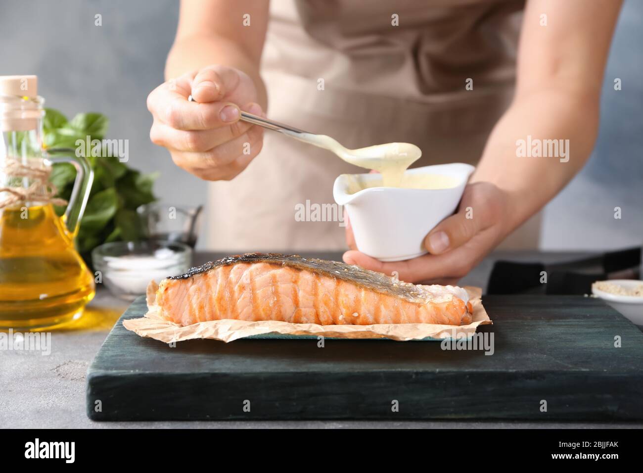 Woman pouring fish sauce on delicious salmon Stock Photo - Alamy