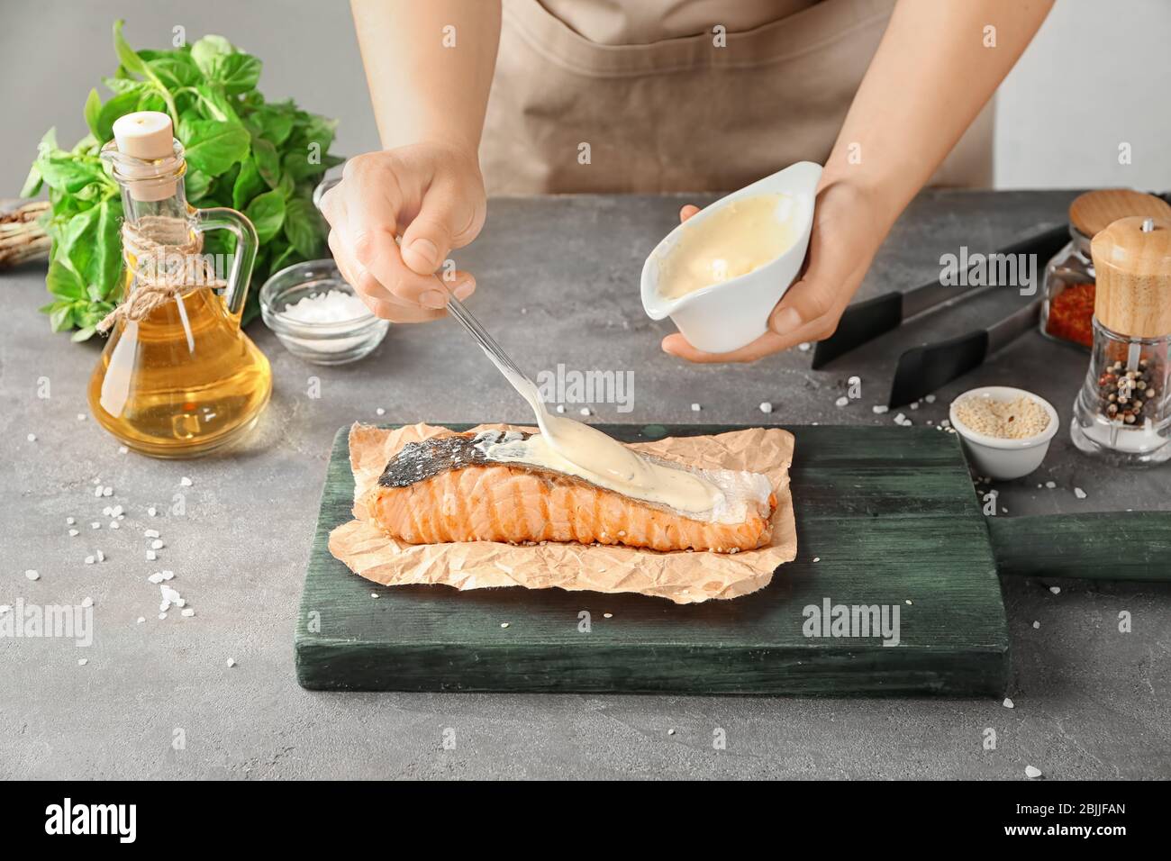 Woman pouring fish sauce on delicious salmon Stock Photo - Alamy