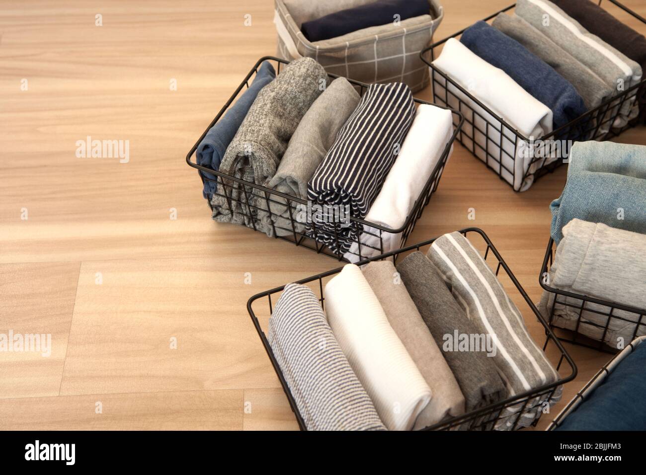 Vertical tidying up storage. Neatly folded clothes neutral colors in ...