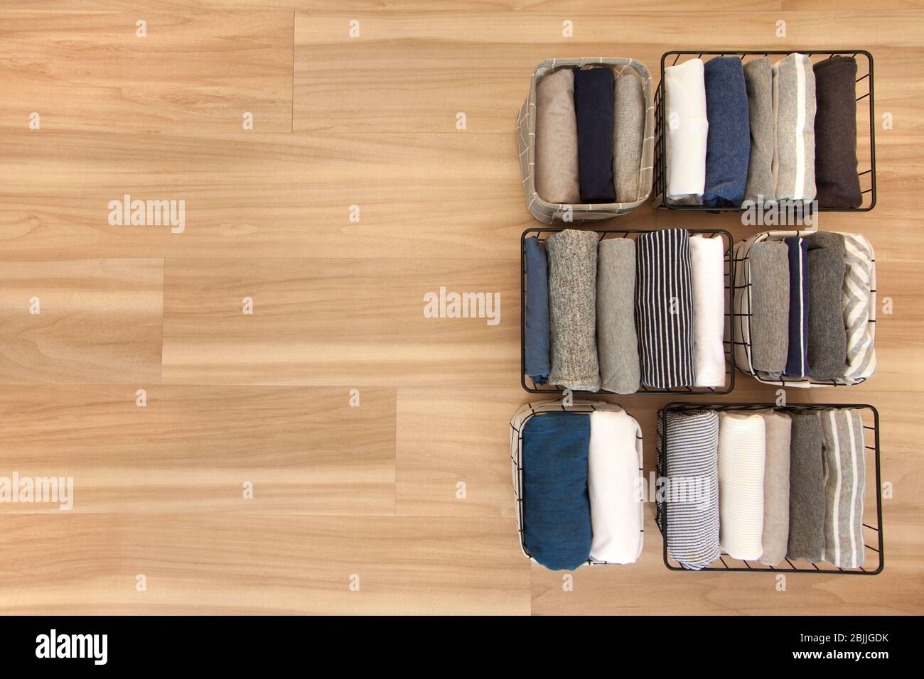 Vertical tidying up storage. Neatly folded clothes neutral colors in ...