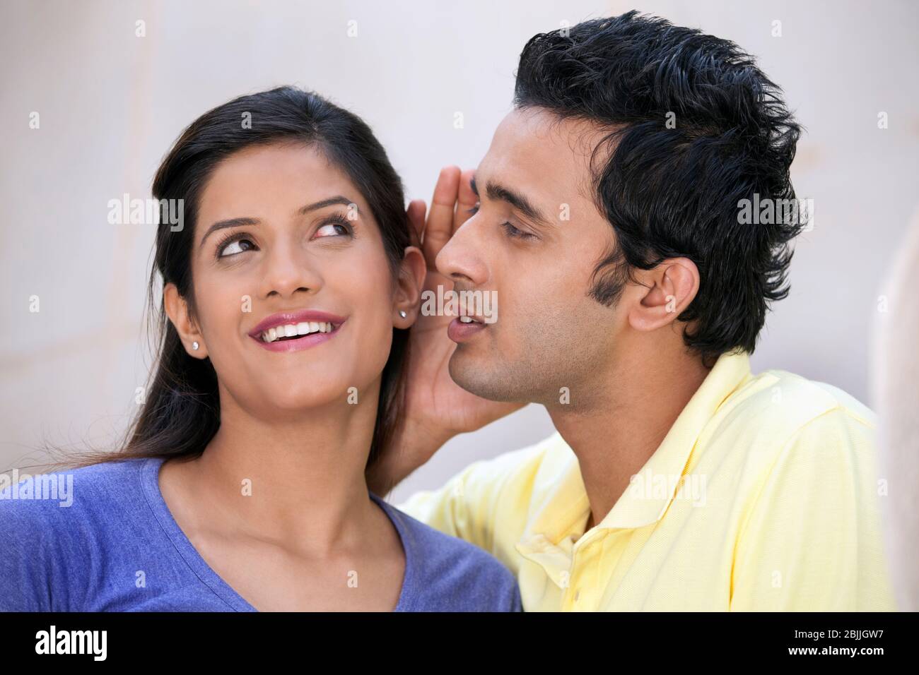 Man whispering in a womans ear Stock Photo - Alamy