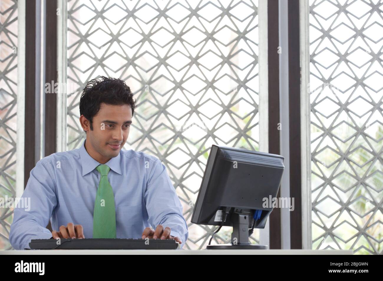 Indian man sitting at reception desk hi-res stock photography and ...