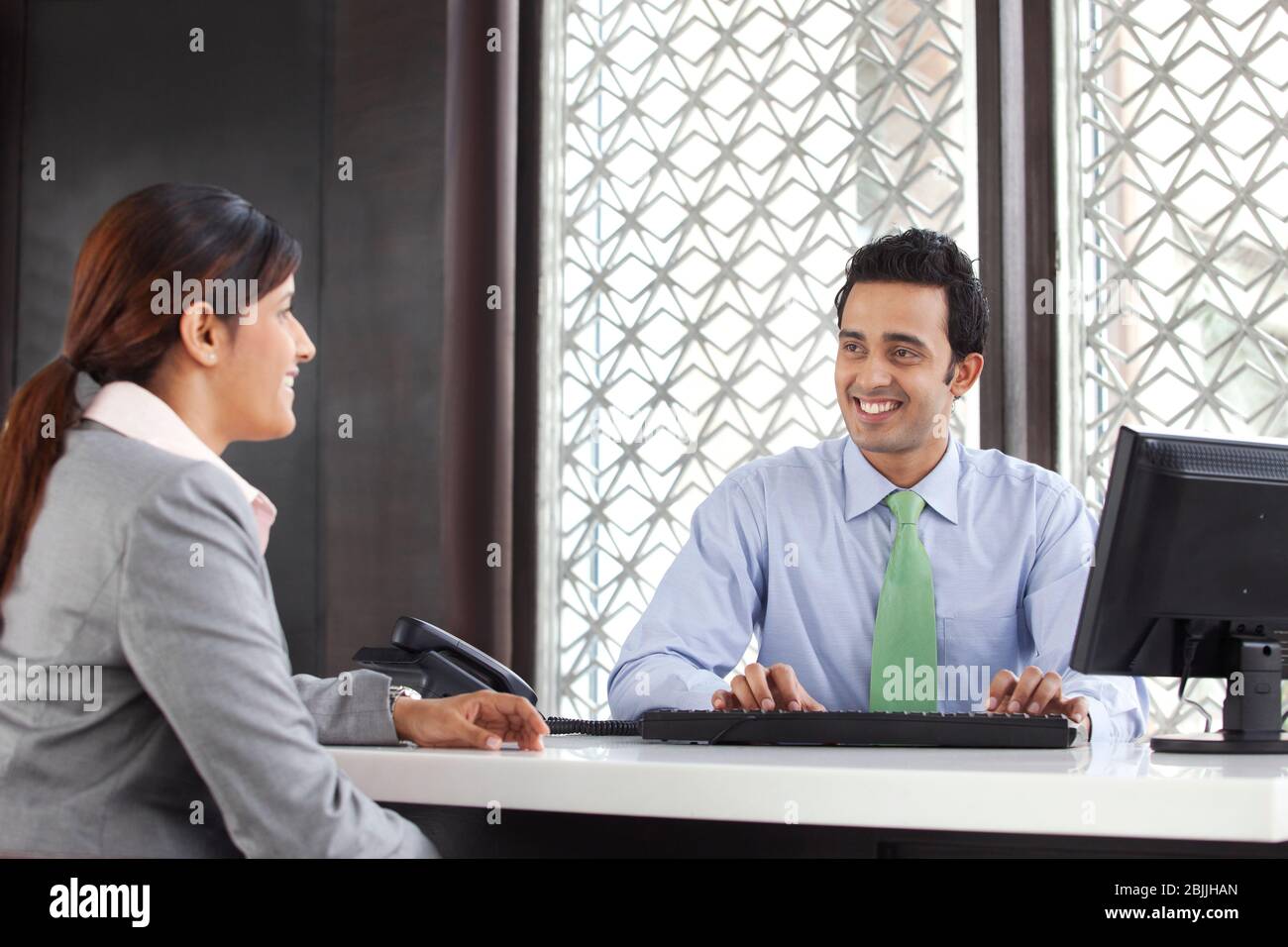 Indian man sitting at reception desk hi-res stock photography and ...