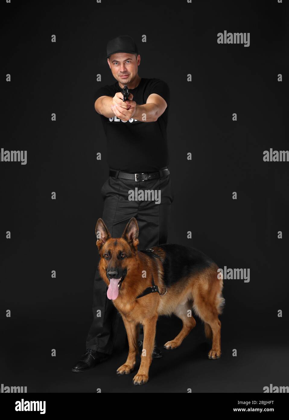 Security guard with dog on black background Stock Photo - Alamy