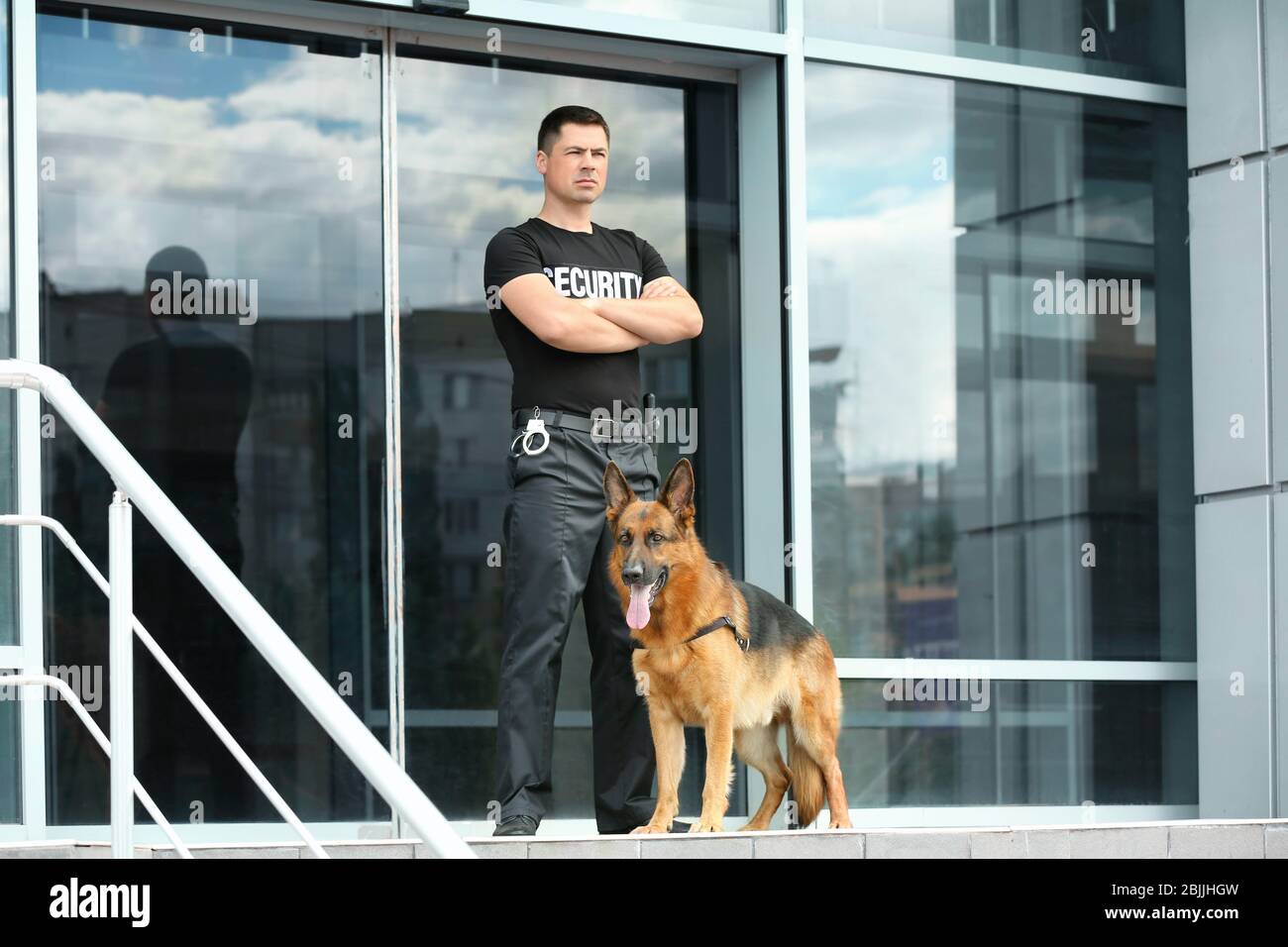 Security guard with dog near building Stock Photo - Alamy