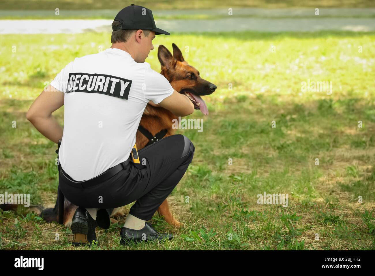 Security guard with dog in park Stock Photo - Alamy