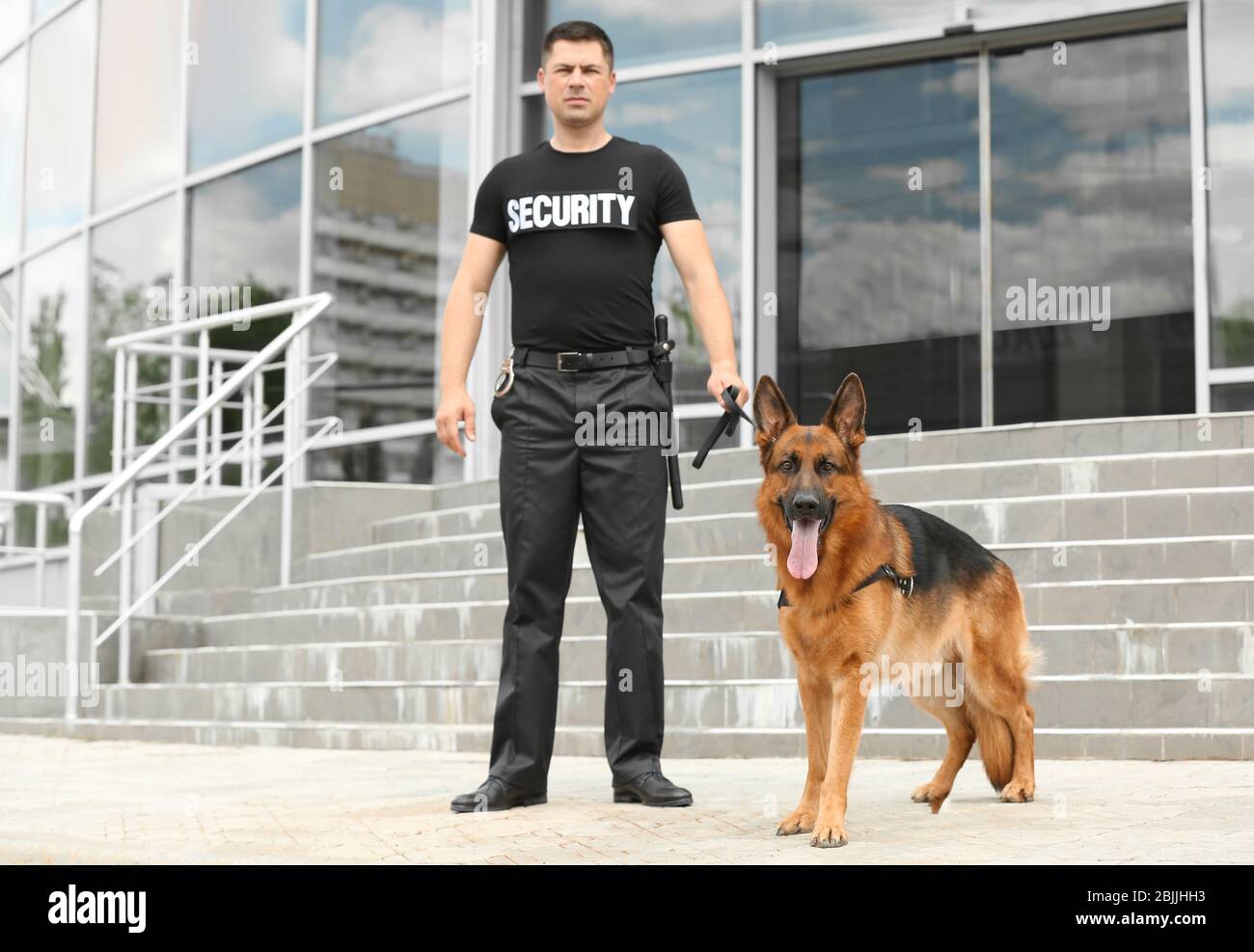 Security guard with dog near building Stock Photo - Alamy