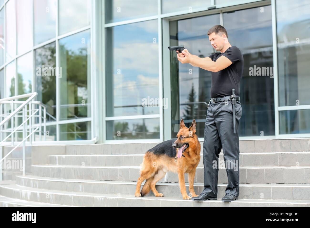 Security guard with dog near building Stock Photo - Alamy