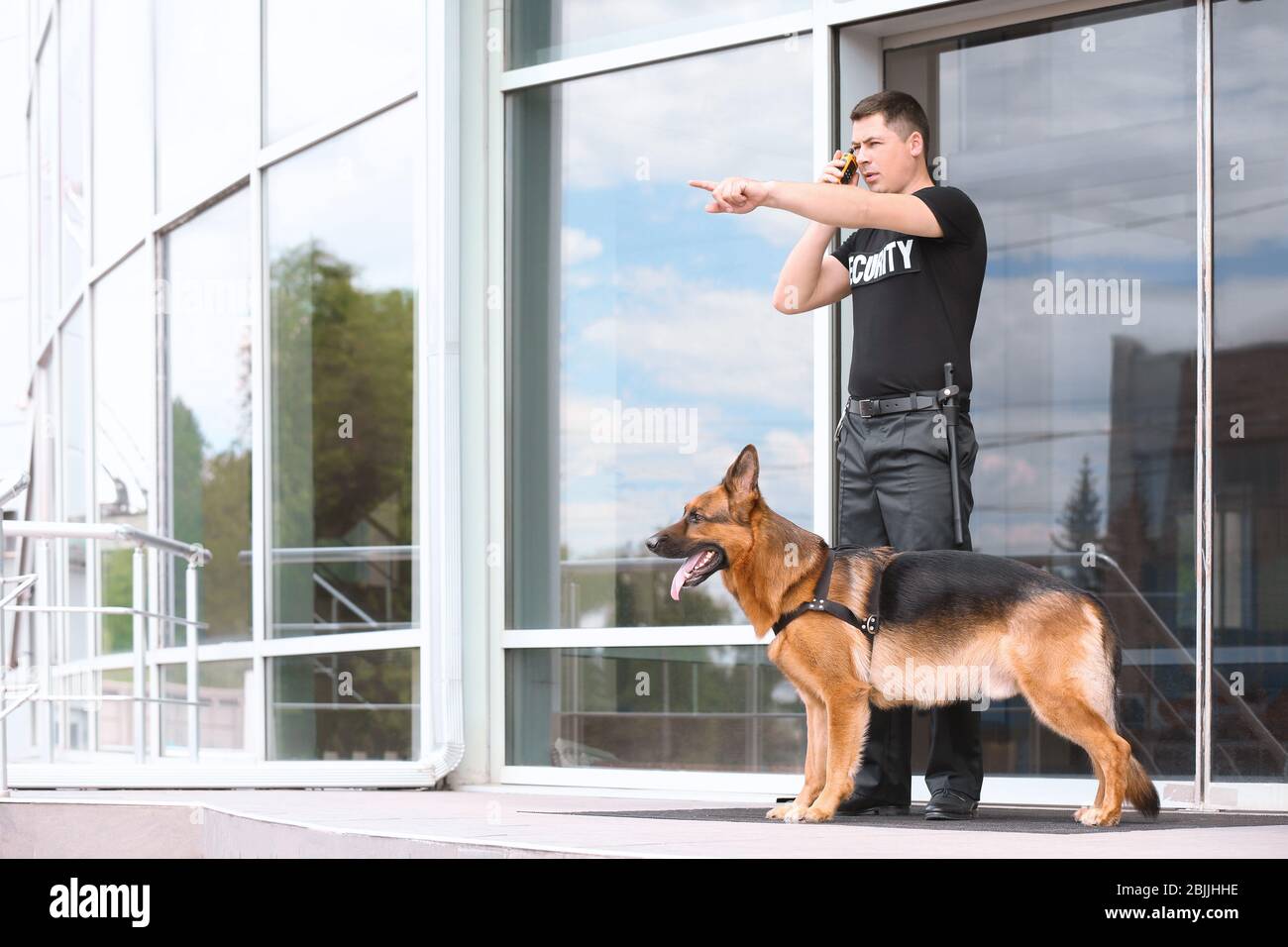 Security guard with dog near building Stock Photo - Alamy