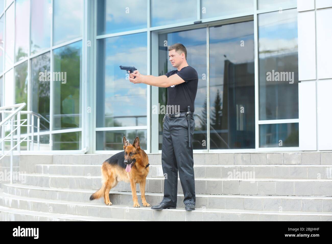 Security guard with dog near building Stock Photo - Alamy