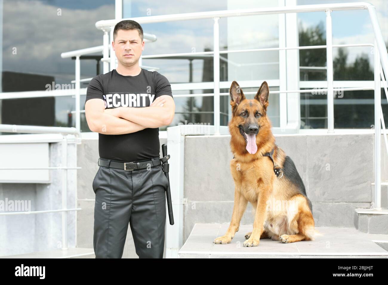 Security guard with dog near building Stock Photo - Alamy