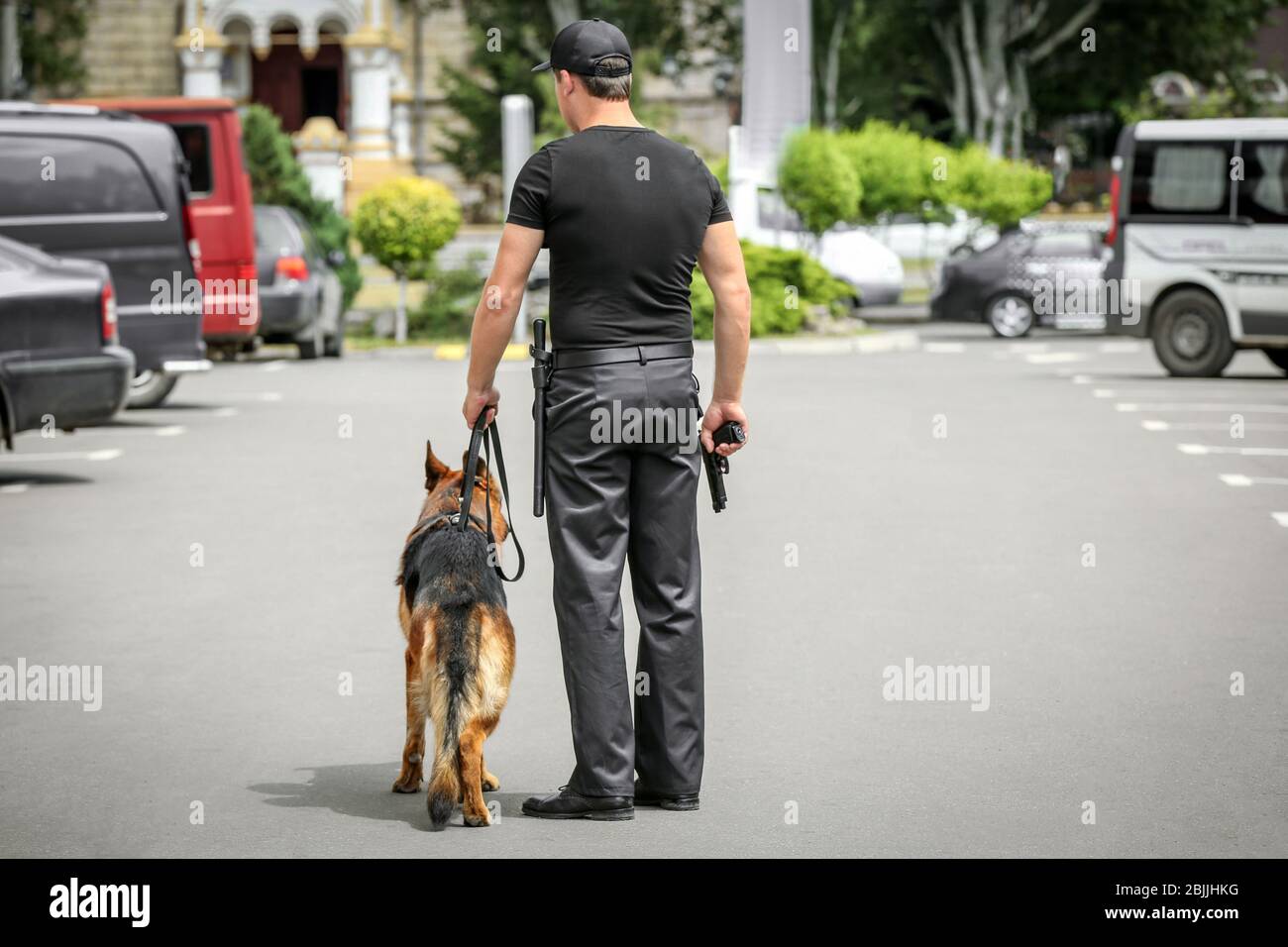 Security guard with dog, outdoors Stock Photo - Alamy