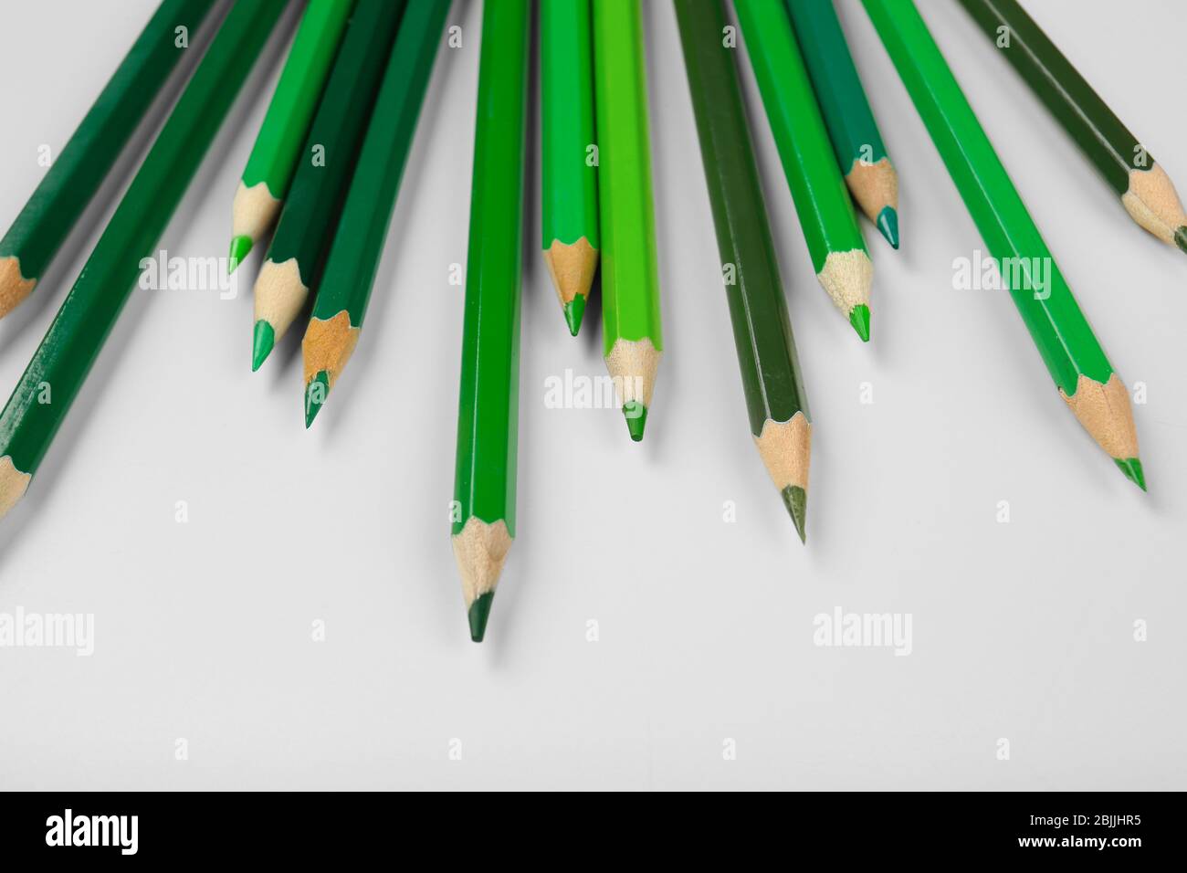 Green pencils of different shades on white background Stock Photo - Alamy