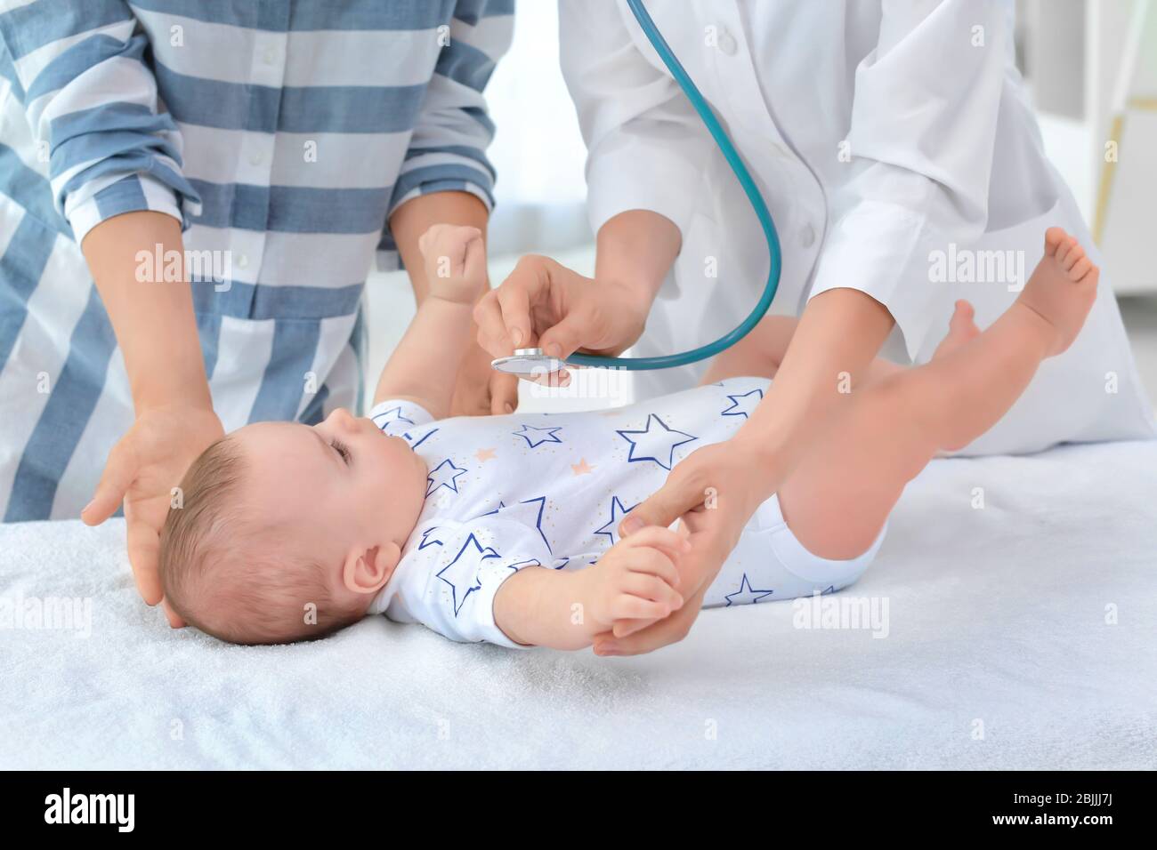 Doctor examining baby with stethoscope at home Stock Photo - Alamy