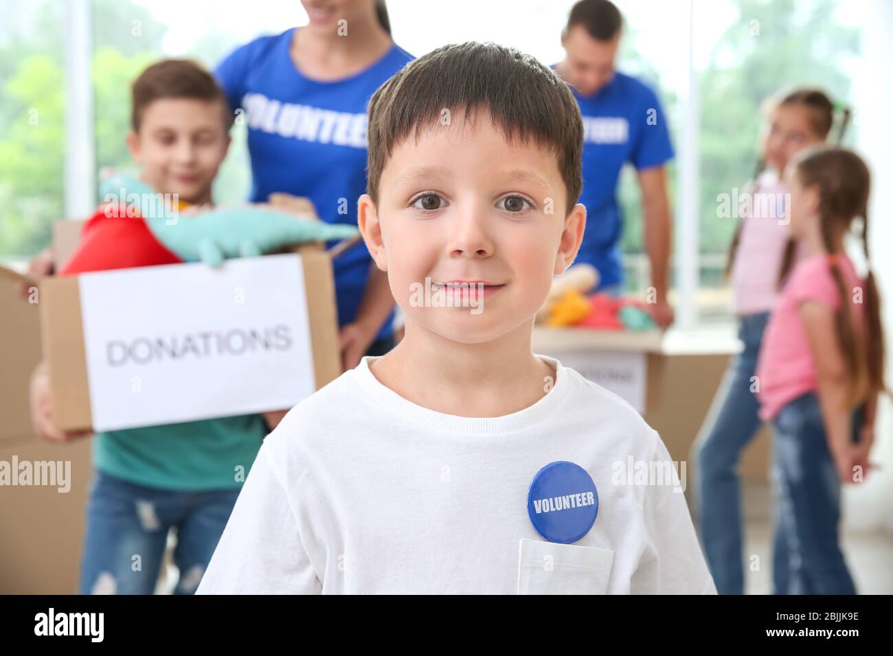 Little boy in shirt with volunteer button on blurred background Stock ...