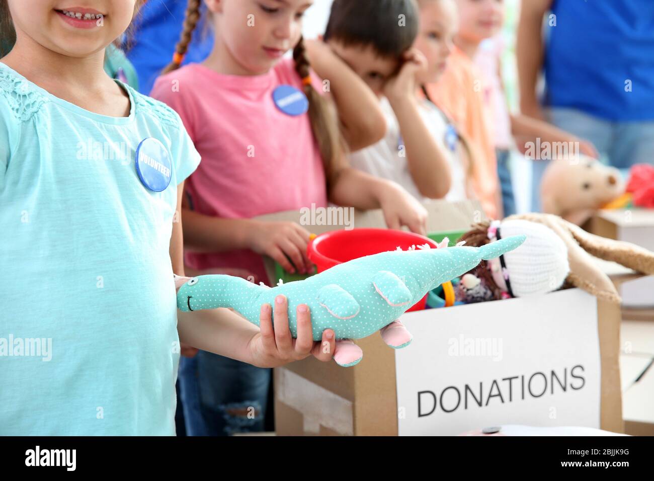 Happy small volunteers sorting donation goods Stock Photo - Alamy