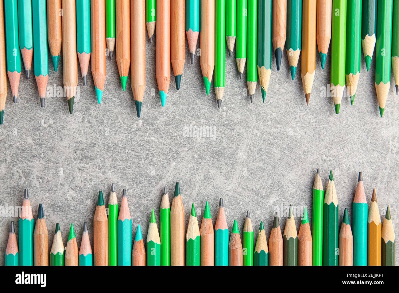 Sharp green pencils on grey background Stock Photo - Alamy
