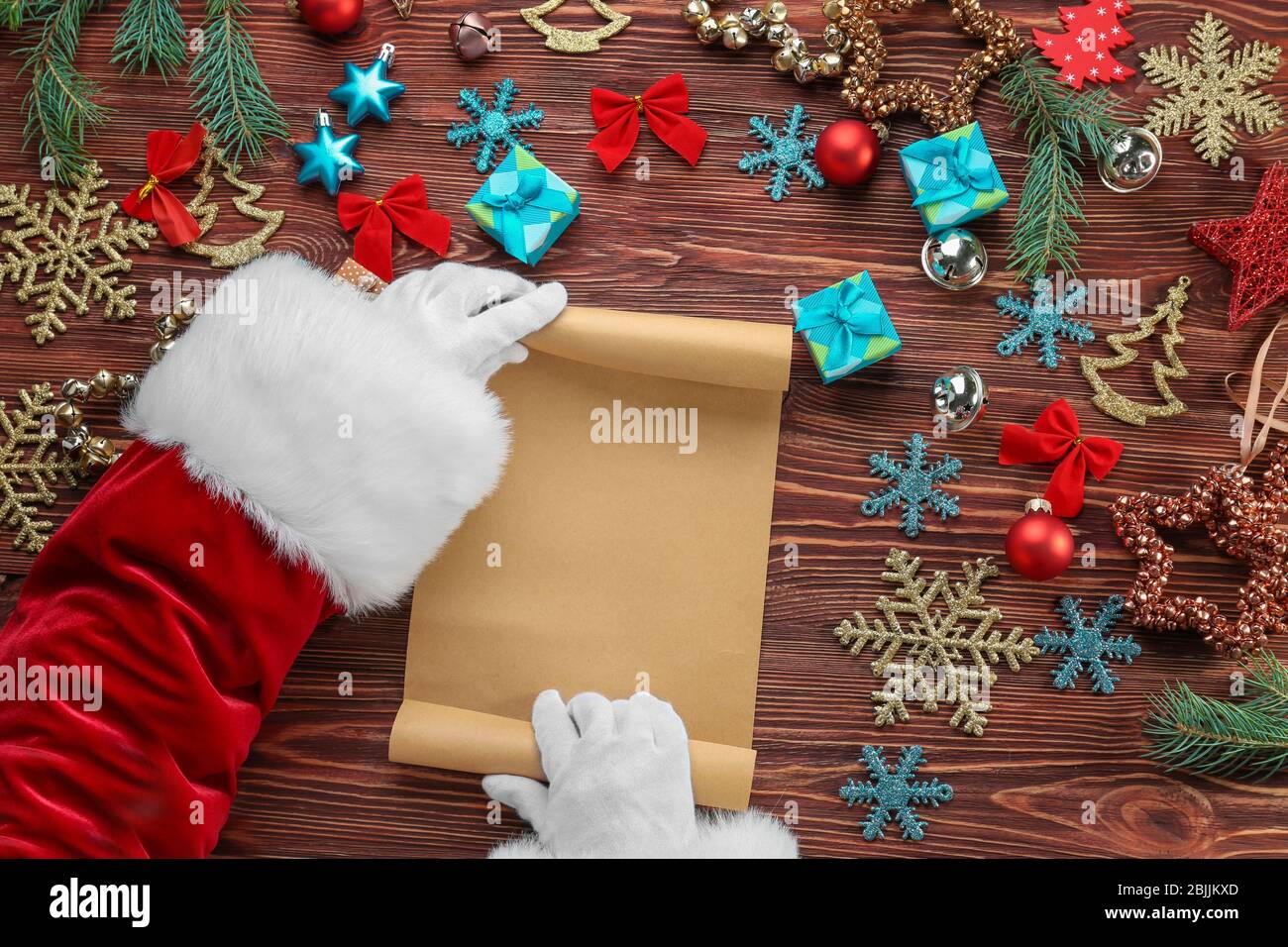 Authentic Santa Claus holding scroll at wooden table Stock Photo - Alamy