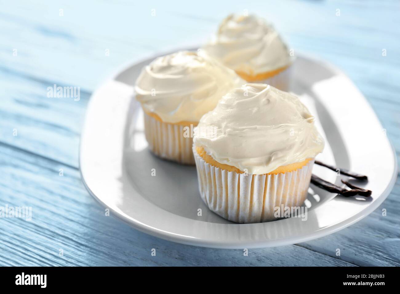 Tasty vanilla cupcakes on plate Stock Photo - Alamy