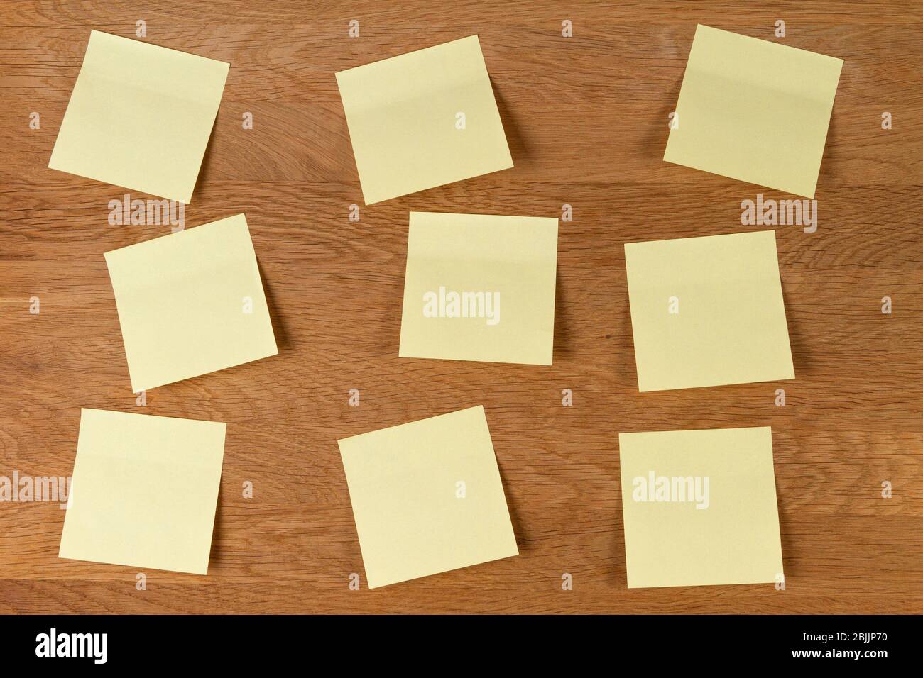 Sticky notes. Blank yellow square paper stickers on natural wooden ...