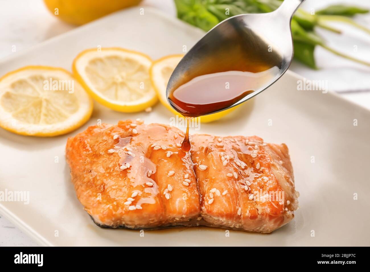 Pouring sauce on delicious fish fillet, close up Stock Photo - Alamy