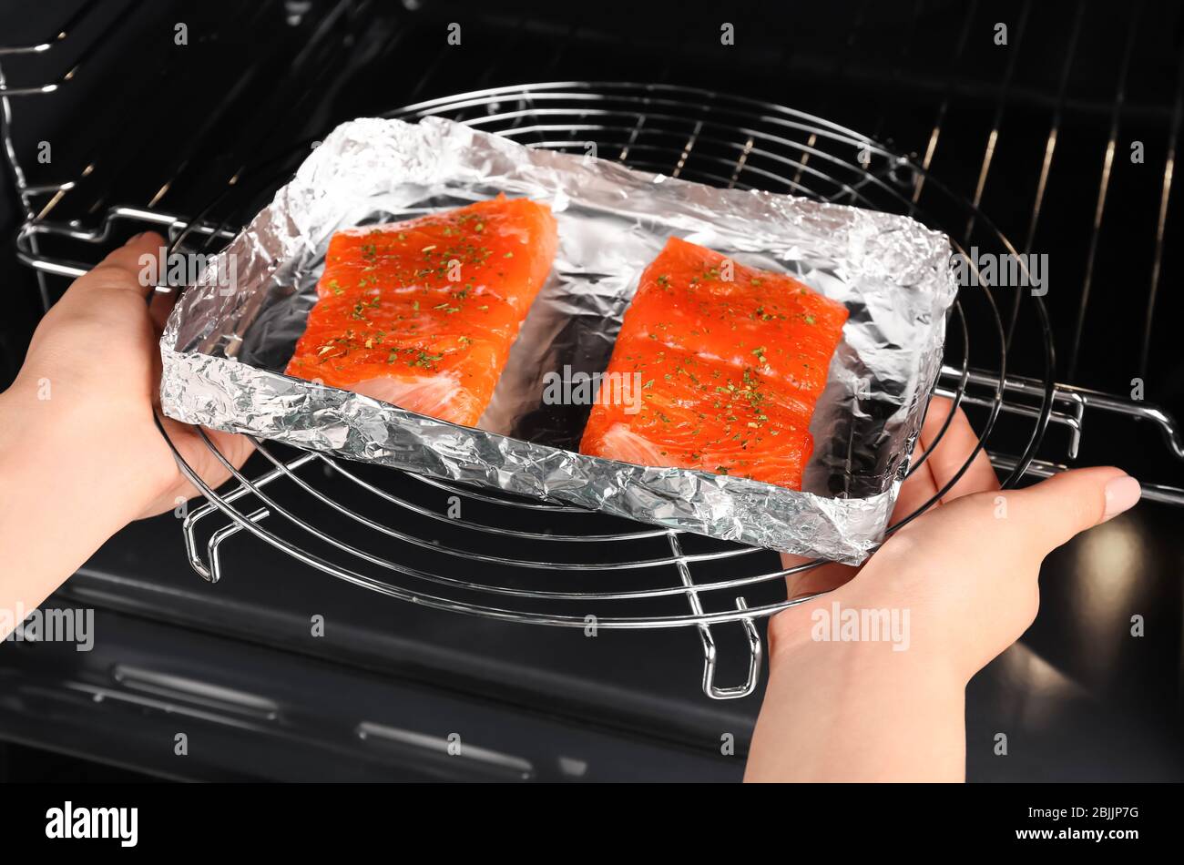 Woman cooking raw fish hi-res stock photography and images - Alamy