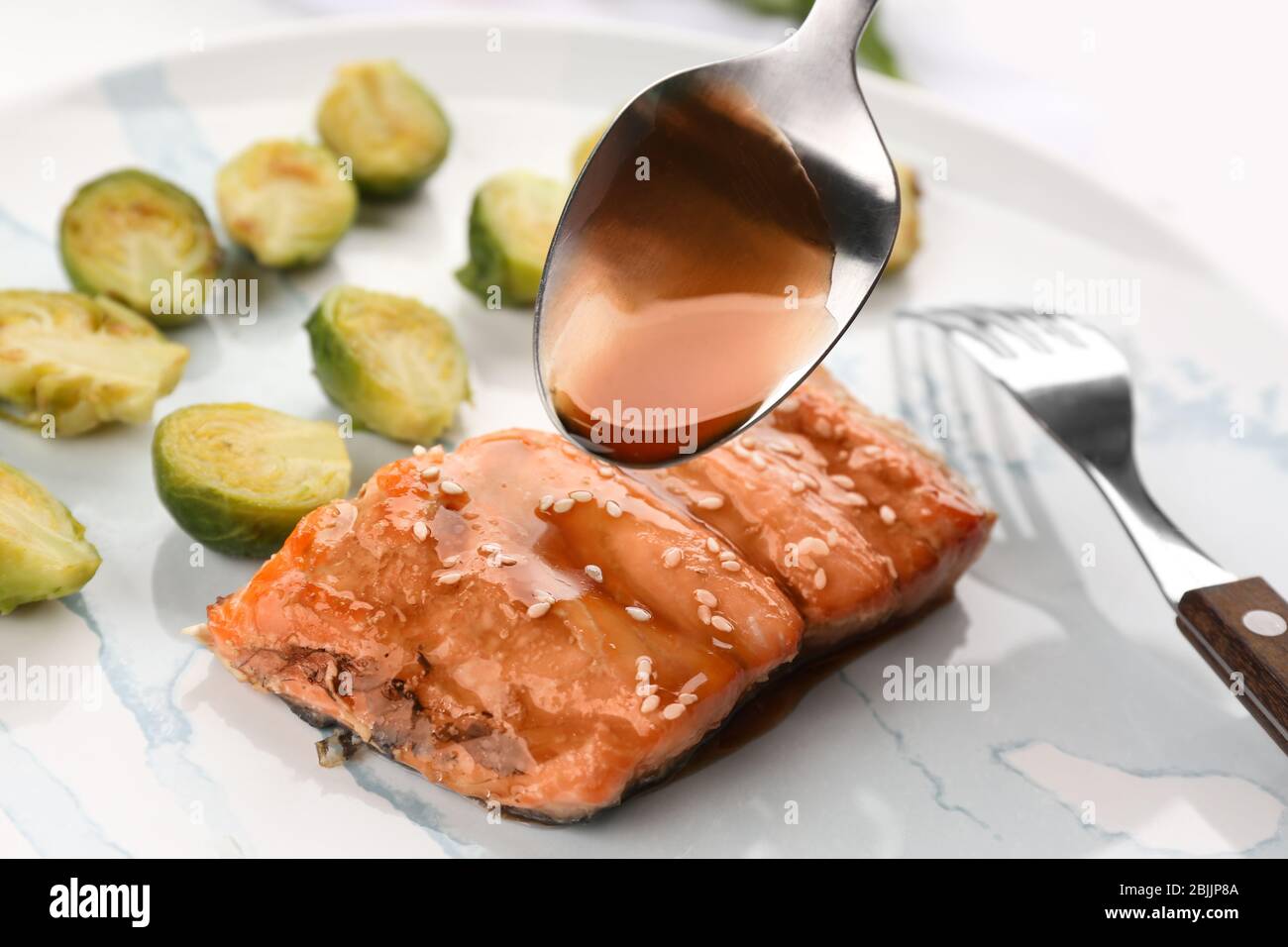 Pouring sauce on delicious fish fillet, close up Stock Photo - Alamy