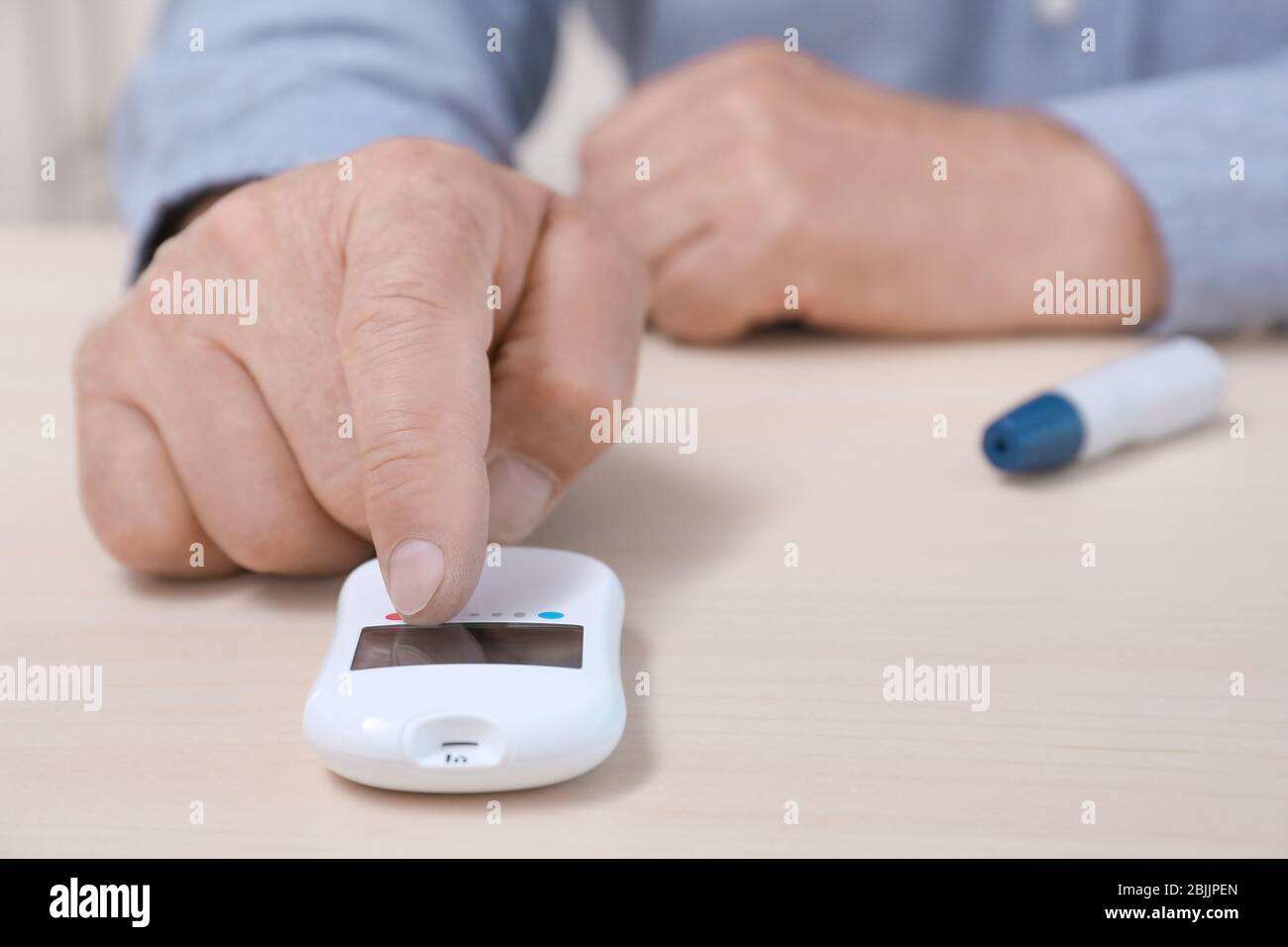 Man using digital glucometer indoors Stock Photo - Alamy