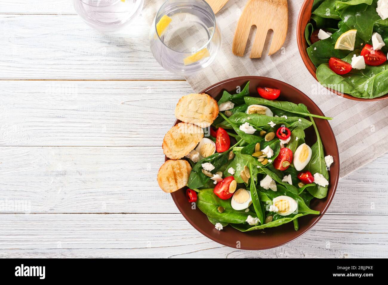 Plate of tasty salad with spinach leaves on wooden table Stock Photo ...