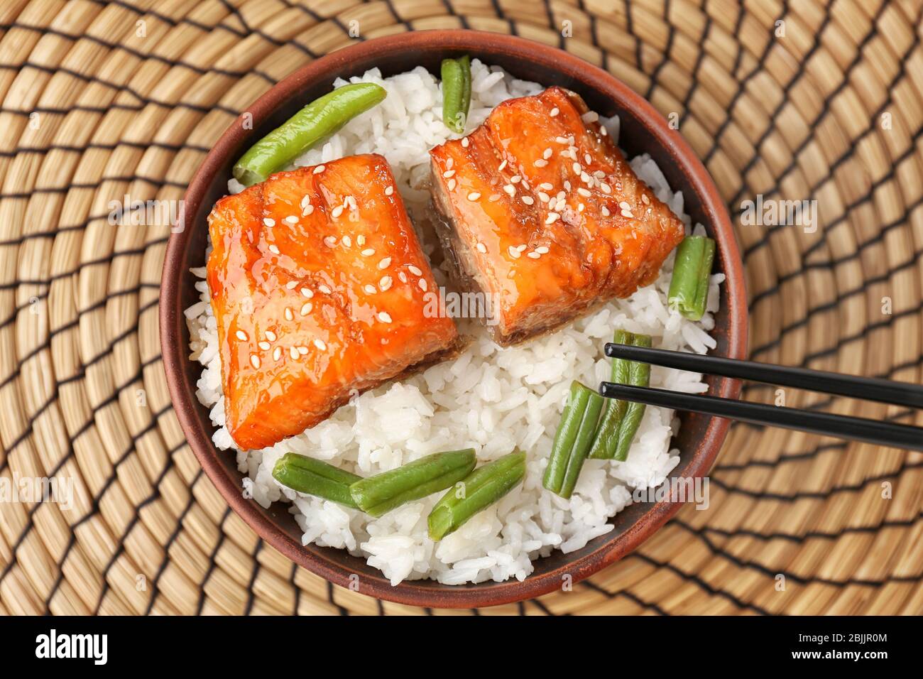 Fish fillet served with rice and green beans on wicker coaster Stock ...