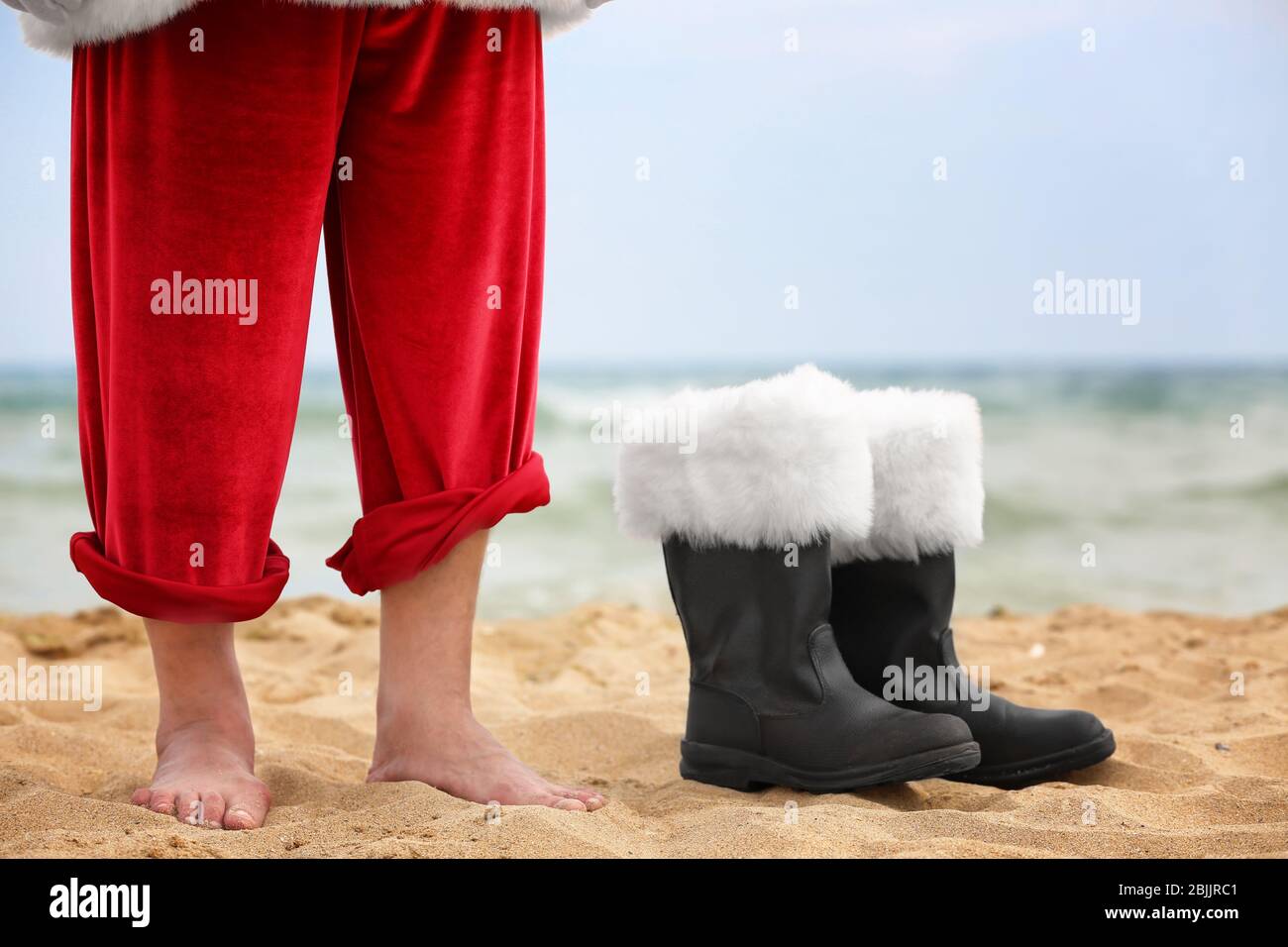 Barefoot Santa Claus and boots on beach Stock Photo - Alamy