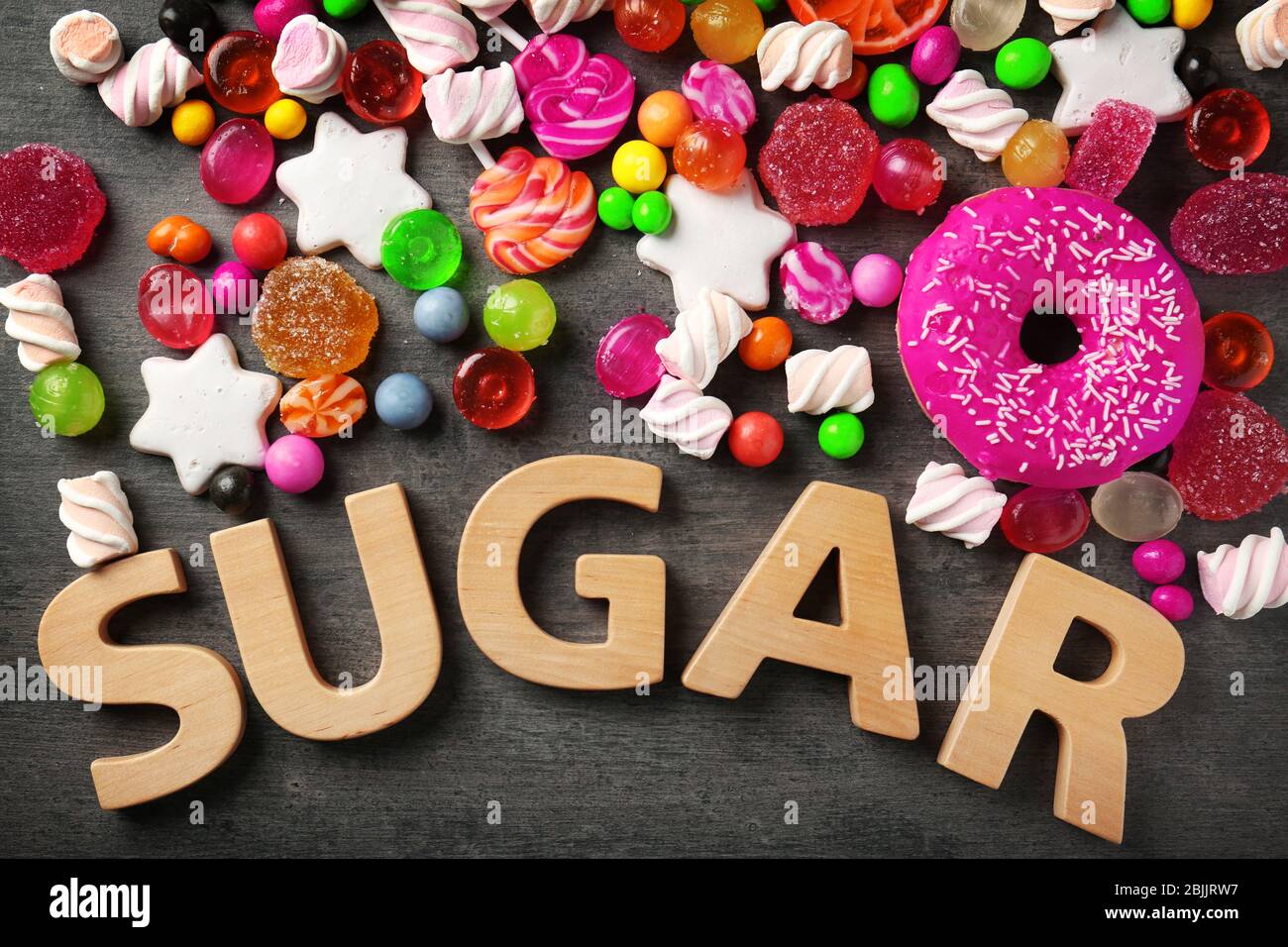 Sugar composition with variety of sweets on grey background Stock Photo ...