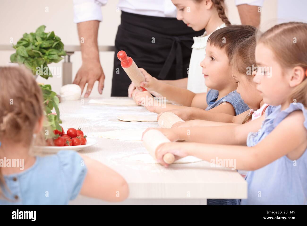 Cute children in kitchen during cooking classes Stock Photo - Alamy
