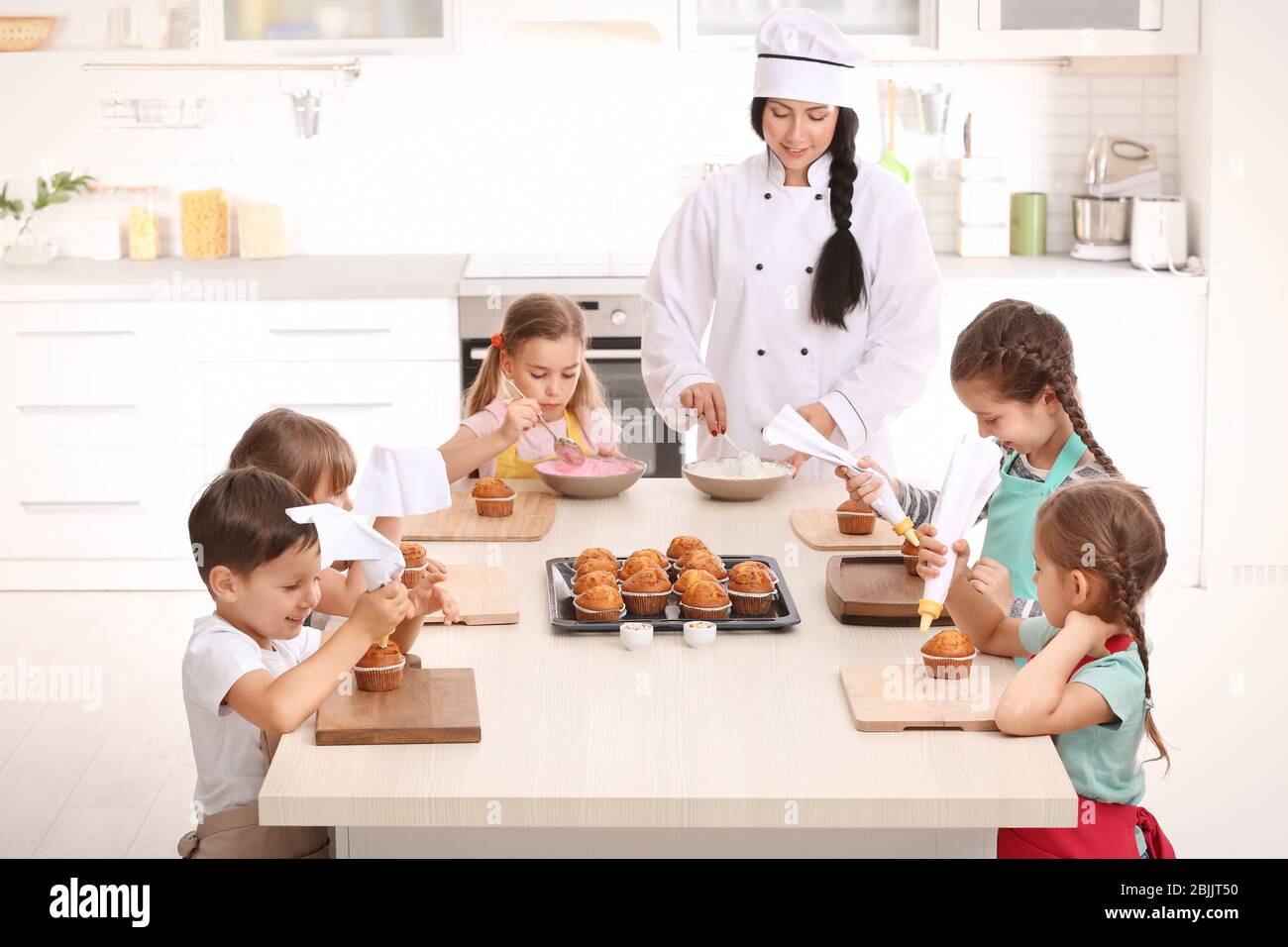 Group of children and teacher in kitchen during cooking classes Stock ...
