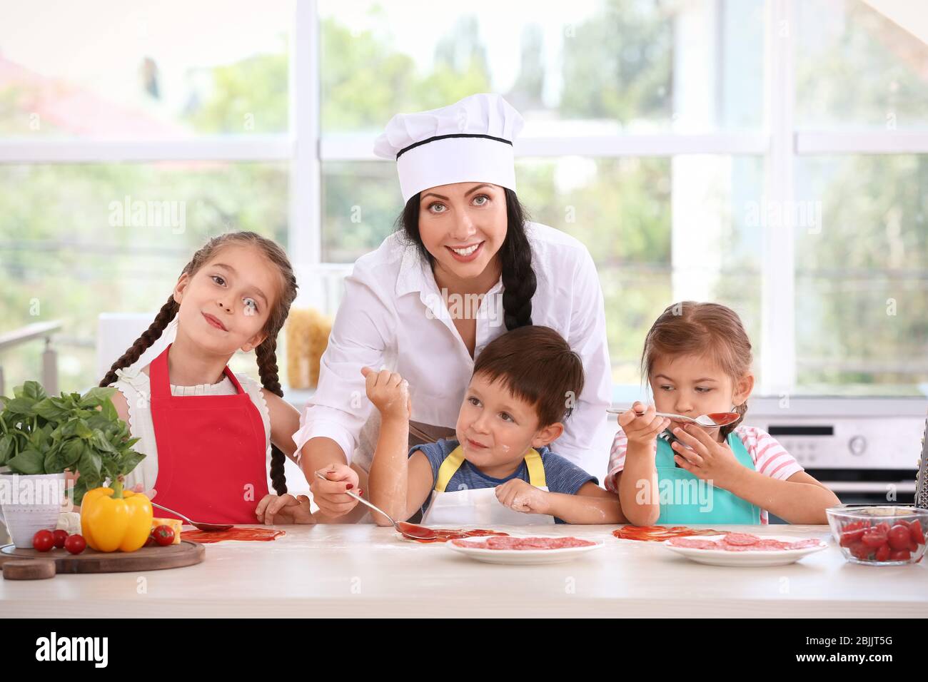 Group of children and teacher in kitchen during cooking classes Stock ...