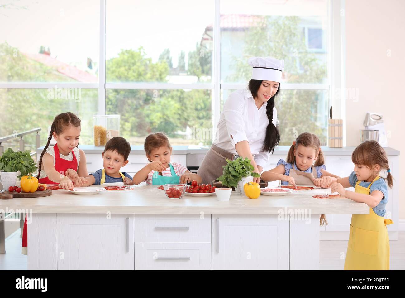 Group of children and teacher in kitchen during cooking classes Stock ...
