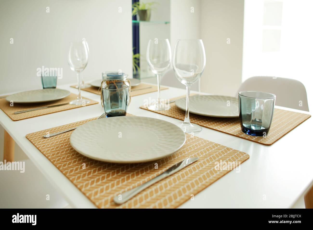 Interior of light modern dining room with served table Stock Photo - Alamy