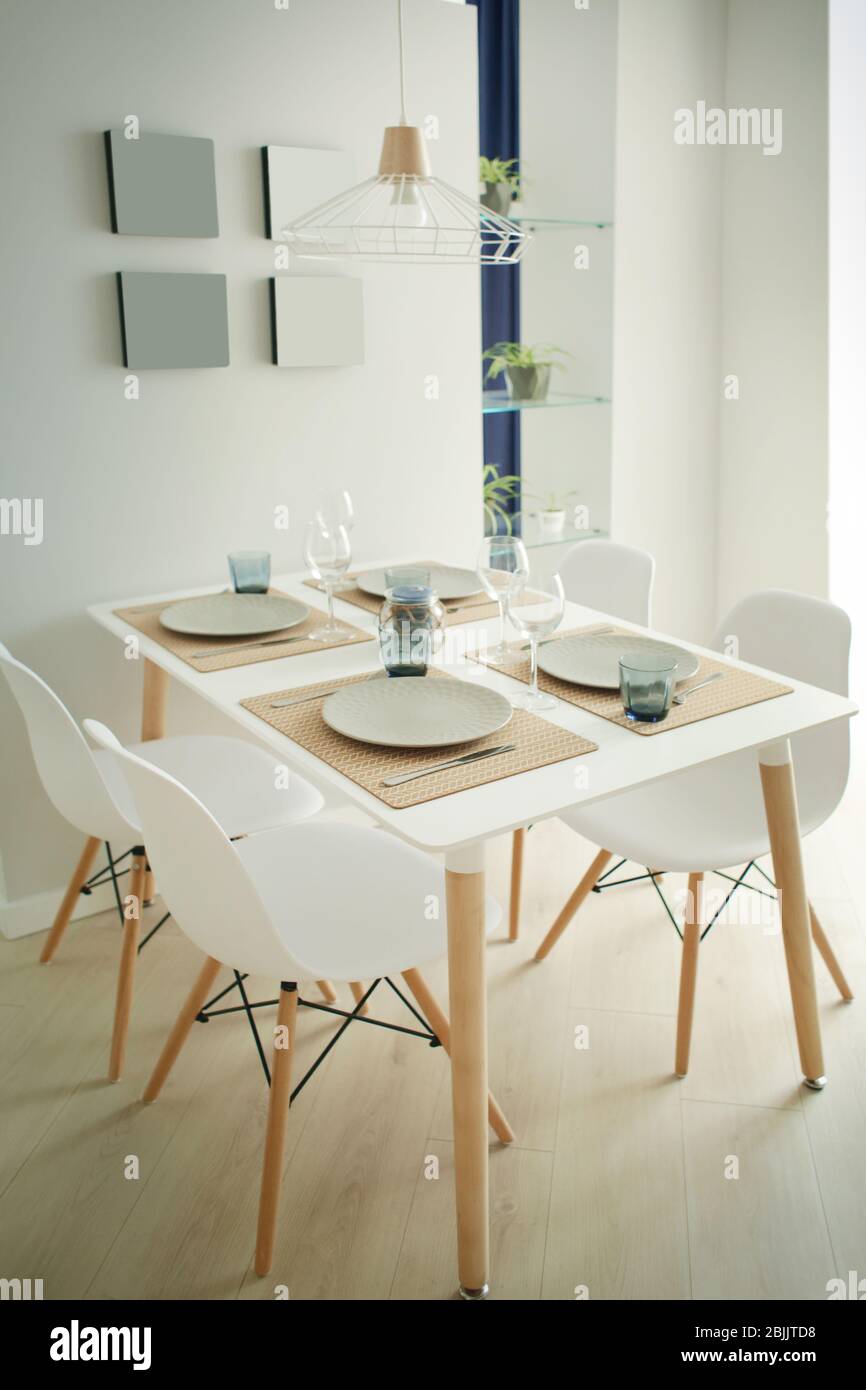 Interior of light modern dining room with served table Stock Photo - Alamy