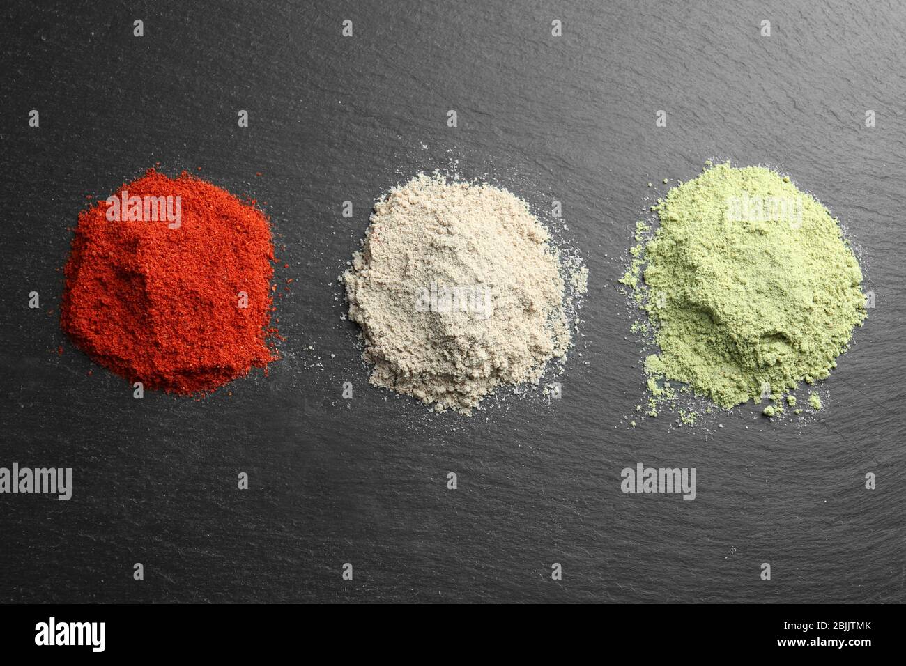 Different superfood powders on grey background Stock Photo - Alamy