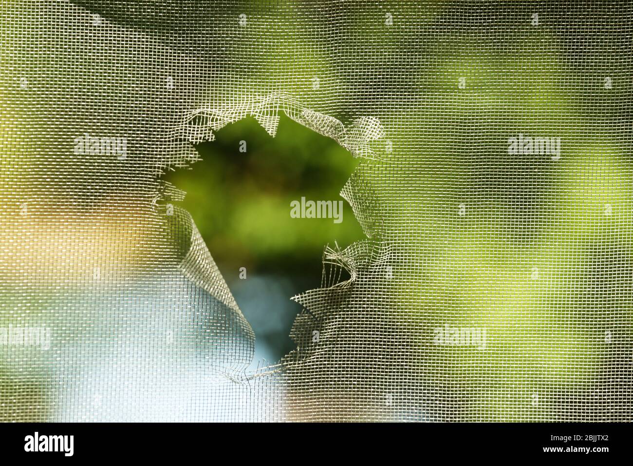 Mosquito screen with hole, close up Stock Photo - Alamy