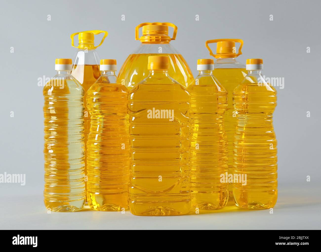 Bottles of cooking oil on light background Stock Photo - Alamy